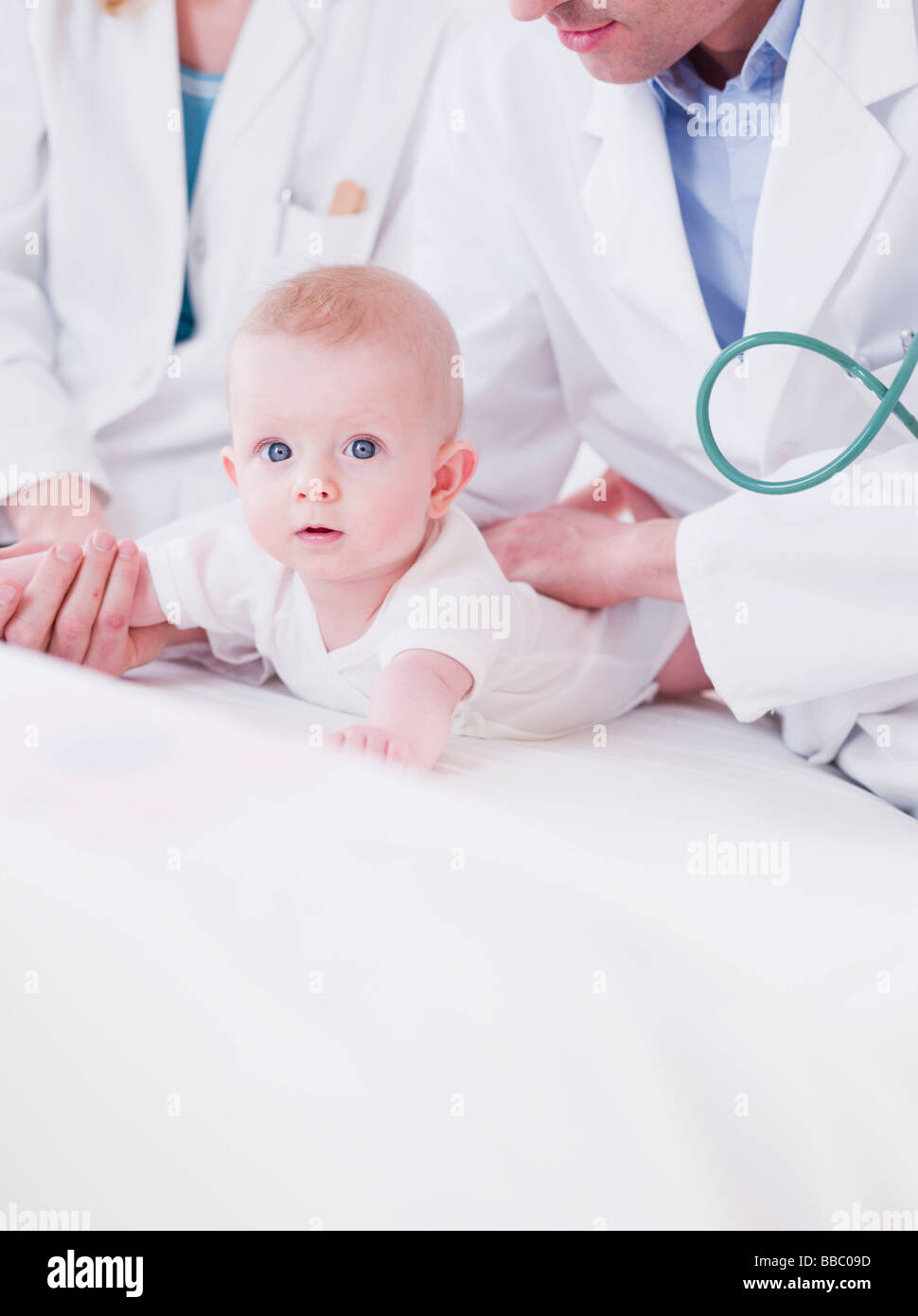 two medics tending to a baby Stock Photo - Alamy