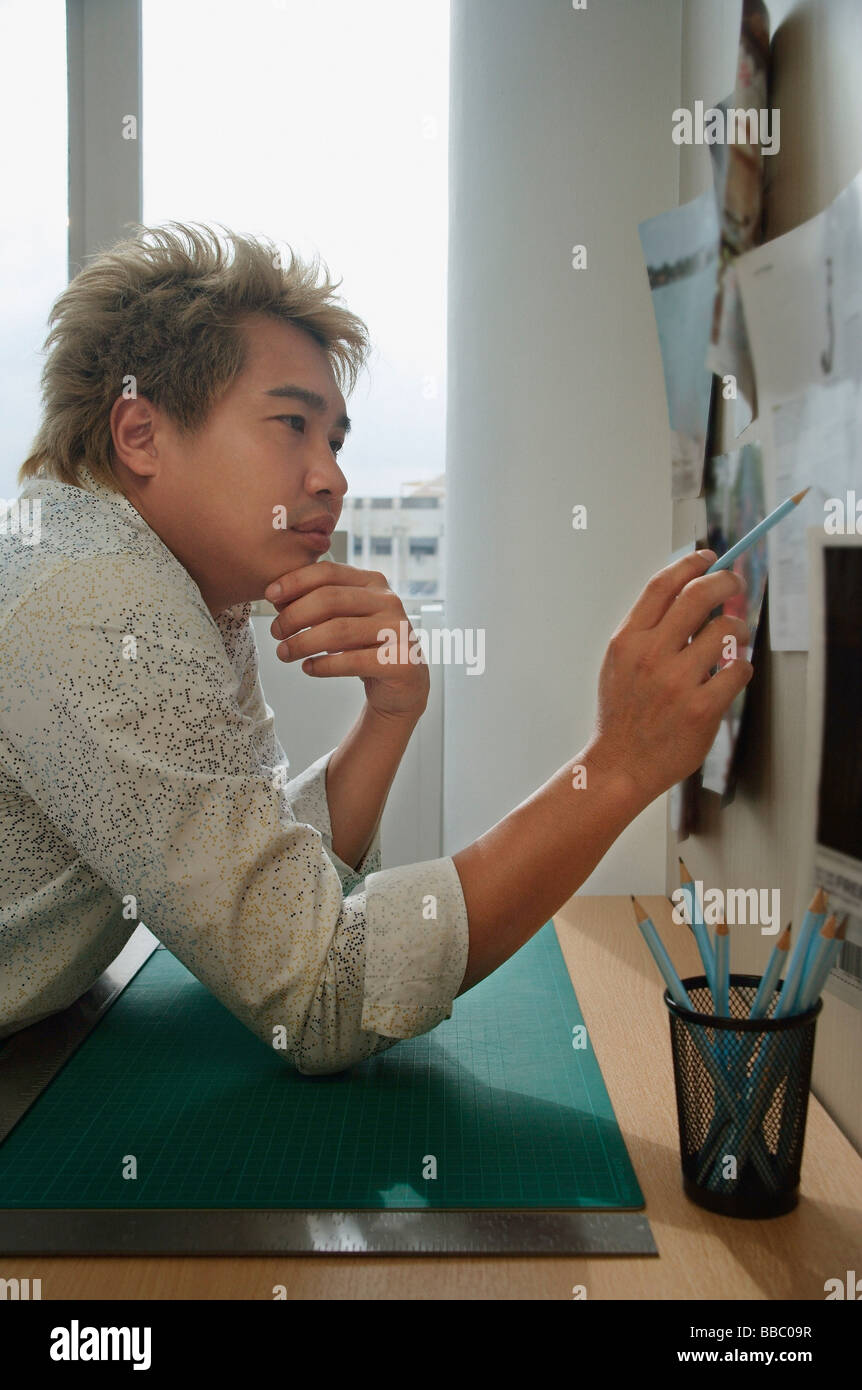Man at desk reading notes Stock Photo - Alamy