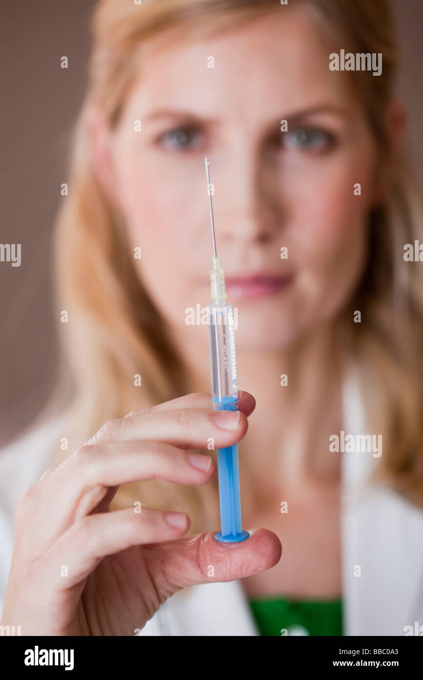 female medic looking at syringe Stock Photo - Alamy