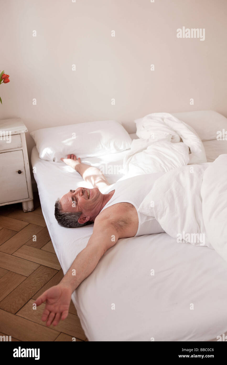 man lying on bed relaxing Stock Photo - Alamy