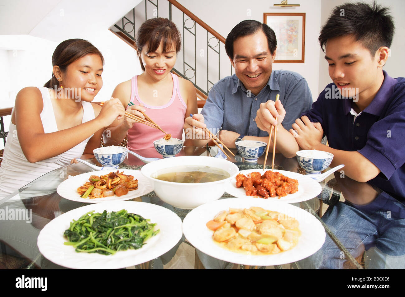 Family at home eating around dining table Stock Photo - Alamy