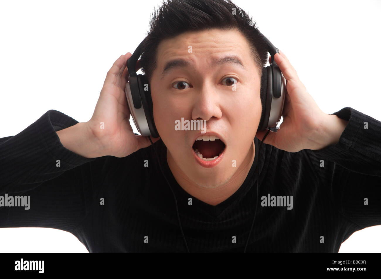 Man with headphones looking surprised at camera Stock Photo - Alamy
