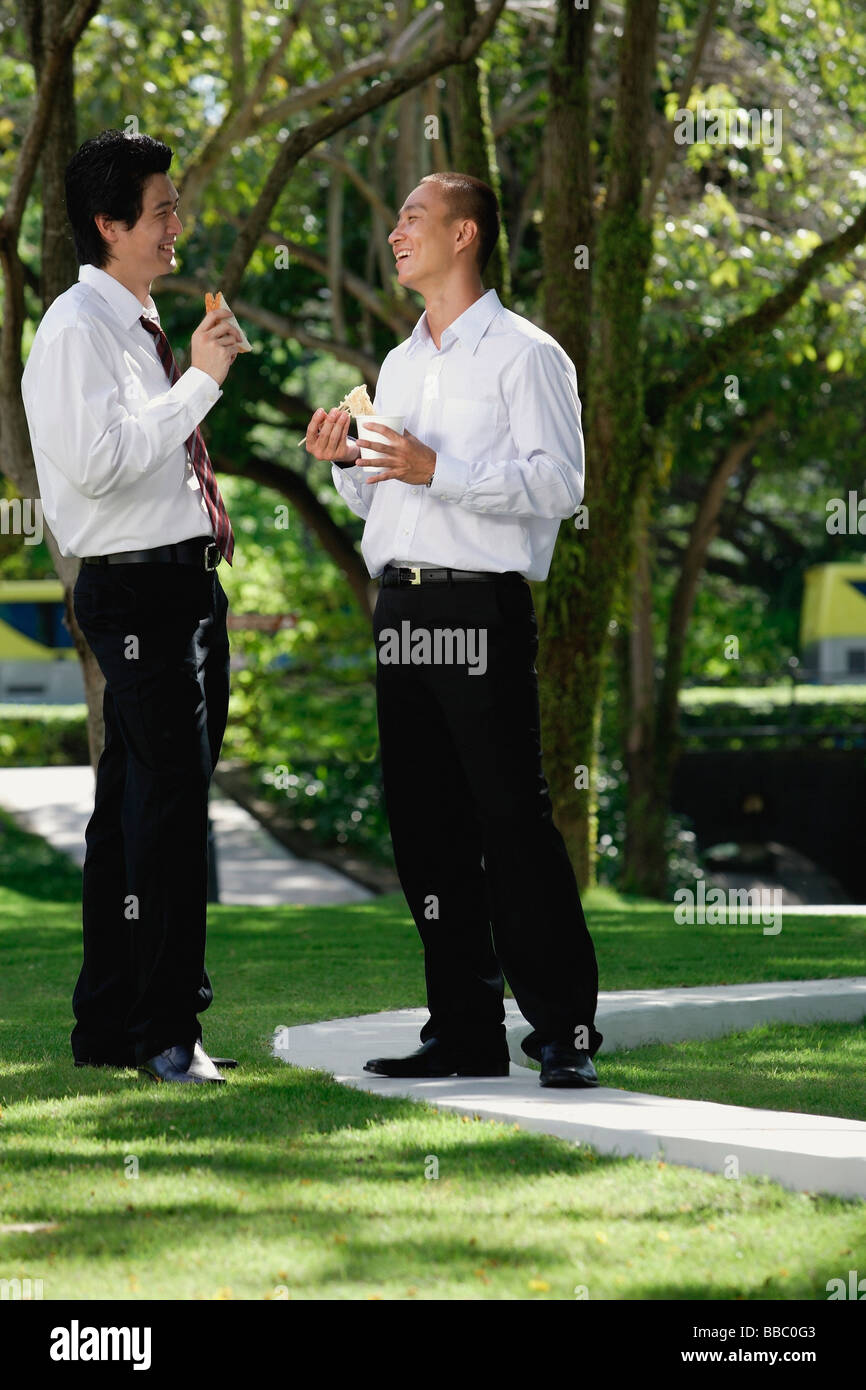 Two men eat their lunch together in the park Stock Photo - Alamy