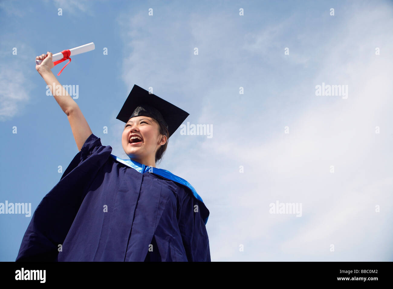 University student in graduation robe cheering Stock Photo - Alamy