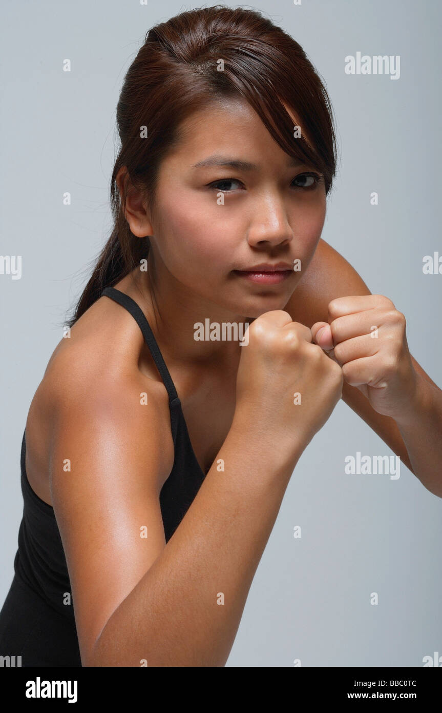 Young woman with fists up looking at camera Stock Photo - Alamy