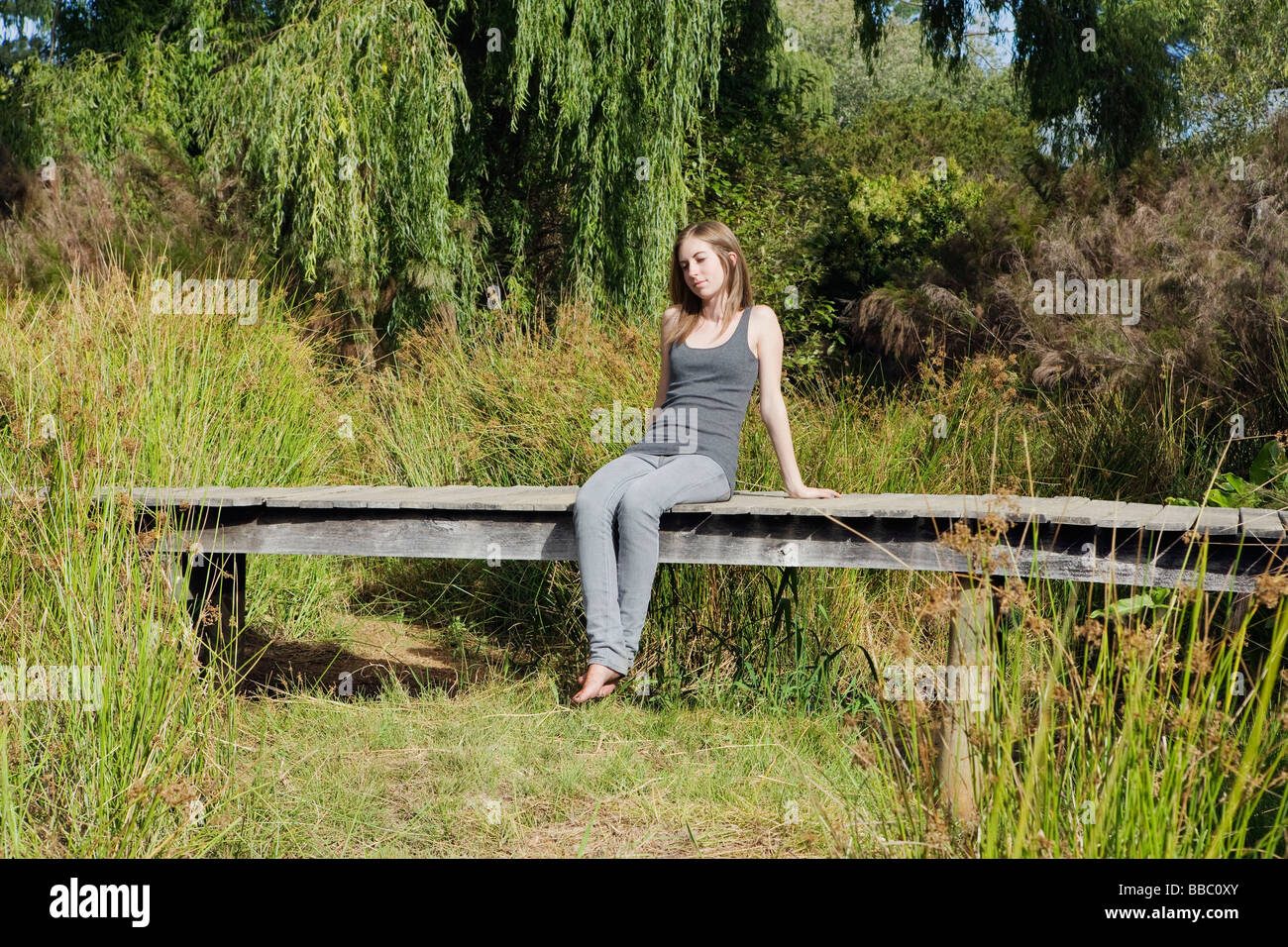Woman sitting on bridge Stock Photo - Alamy