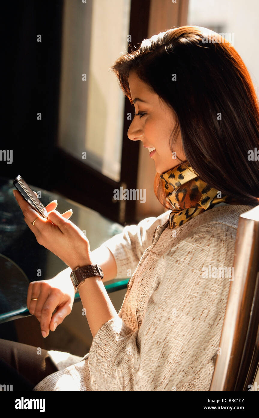 woman smiling as she checks her messages Stock Photo - Alamy