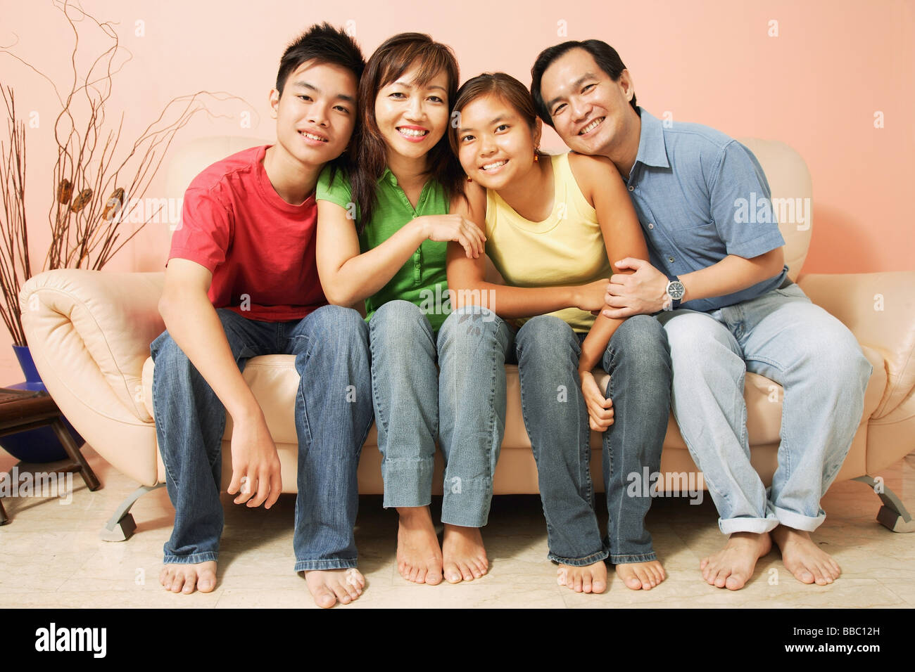 Family of four sitting side by side, looking at camera, portrait Stock ...