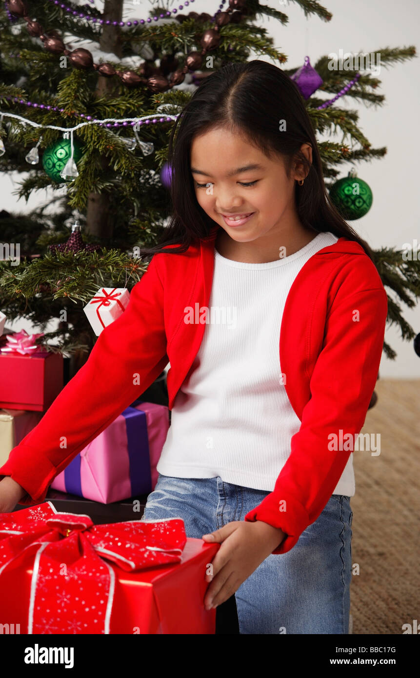 Girl looking at Christmas presents with smile Stock Photo - Alamy