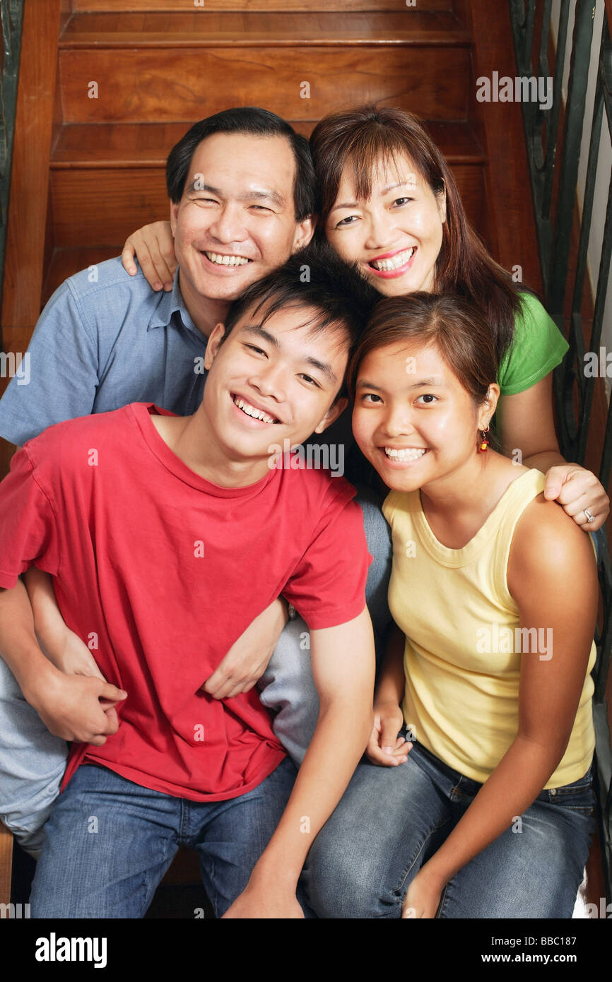 Family of four sitting on stairs, portrait Stock Photo - Alamy