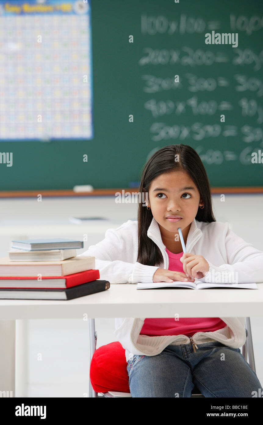 Girl sitting at school desk in classroom Stock Photo - Alamy
