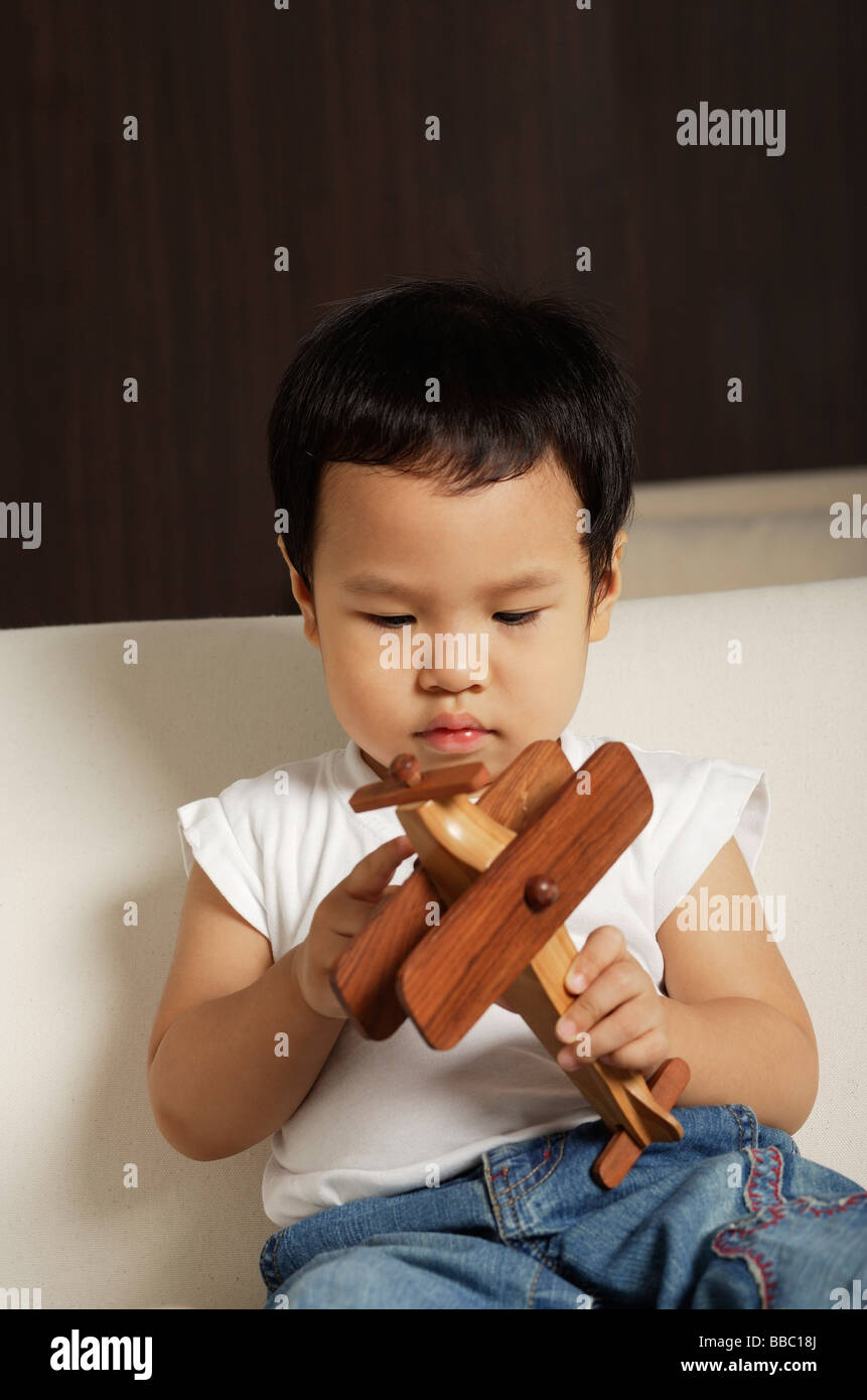 Baby boy playing with wooden toy plane Stock Photo - Alamy