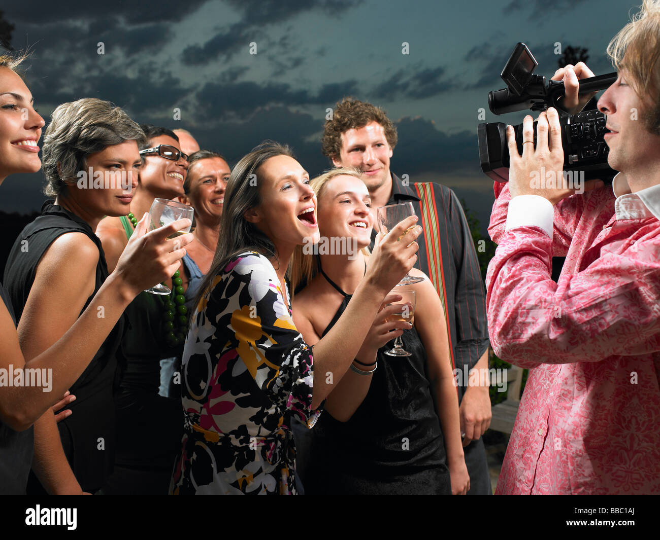 Man filming people at a cocktail party Stock Photo - Alamy