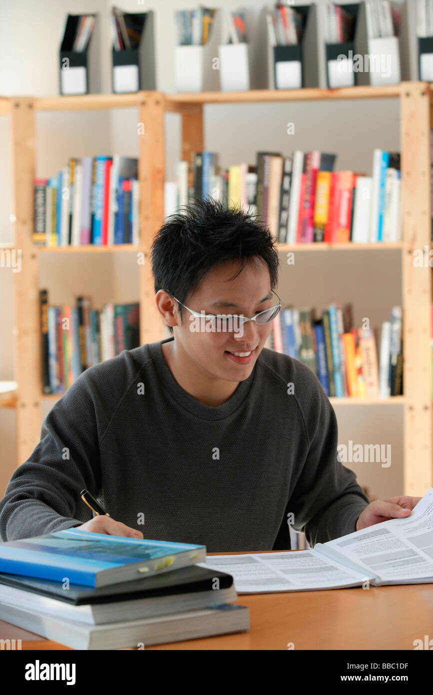 A young man studies in the library Stock Photo - Alamy