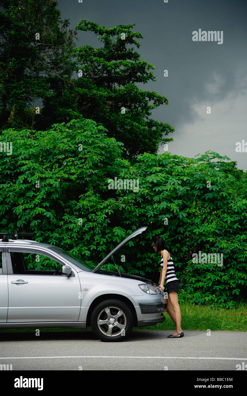 A woman checks under the hood of her car Stock Photo - Alamy