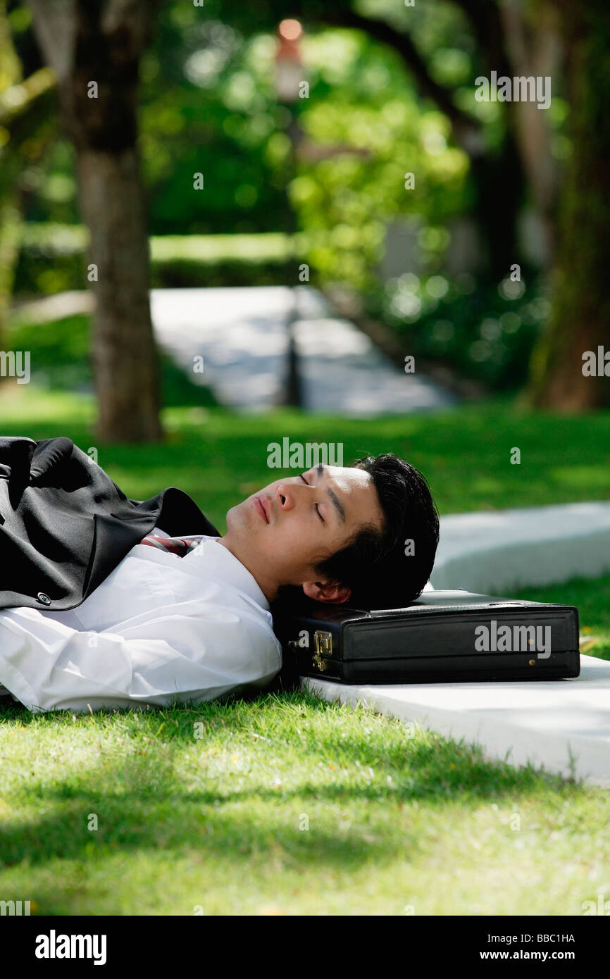 A man lies down and has a rest in the park Stock Photo - Alamy