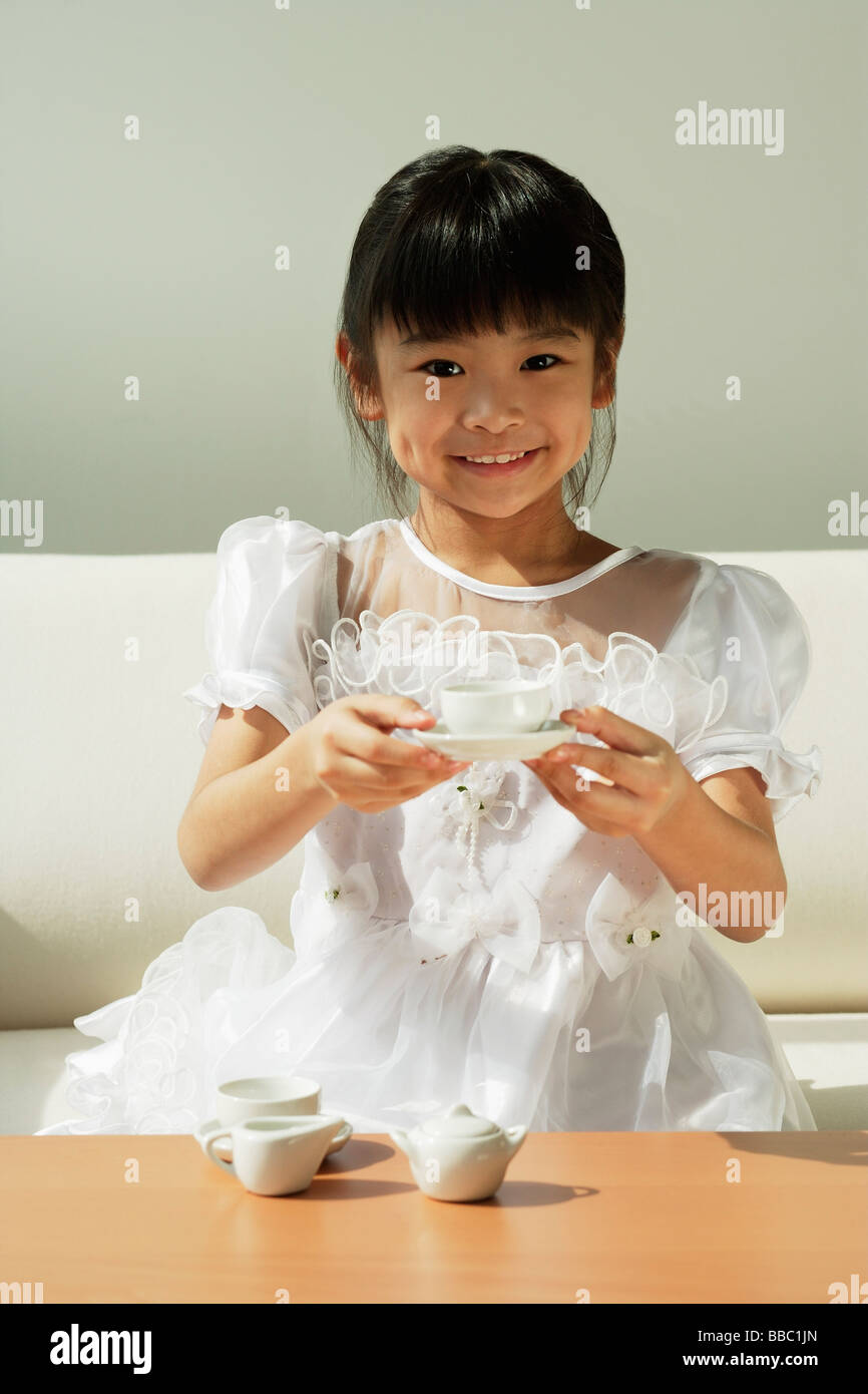 Girl with tea set in hands smiling at camera Stock Photo - Alamy