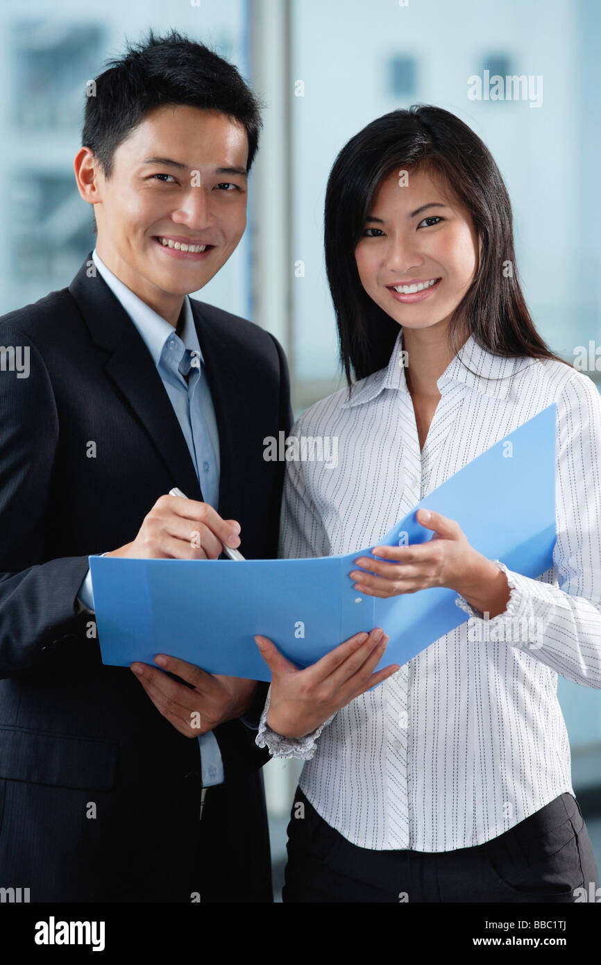 Two work colleagues smile at the camera together Stock Photo - Alamy