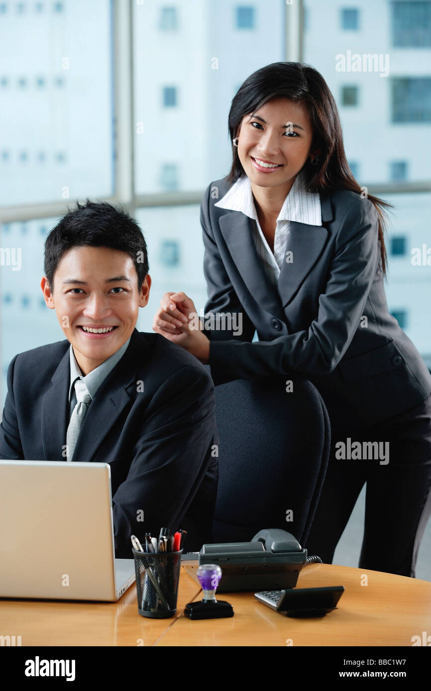 Two work colleagues smile at the camera together Stock Photo - Alamy