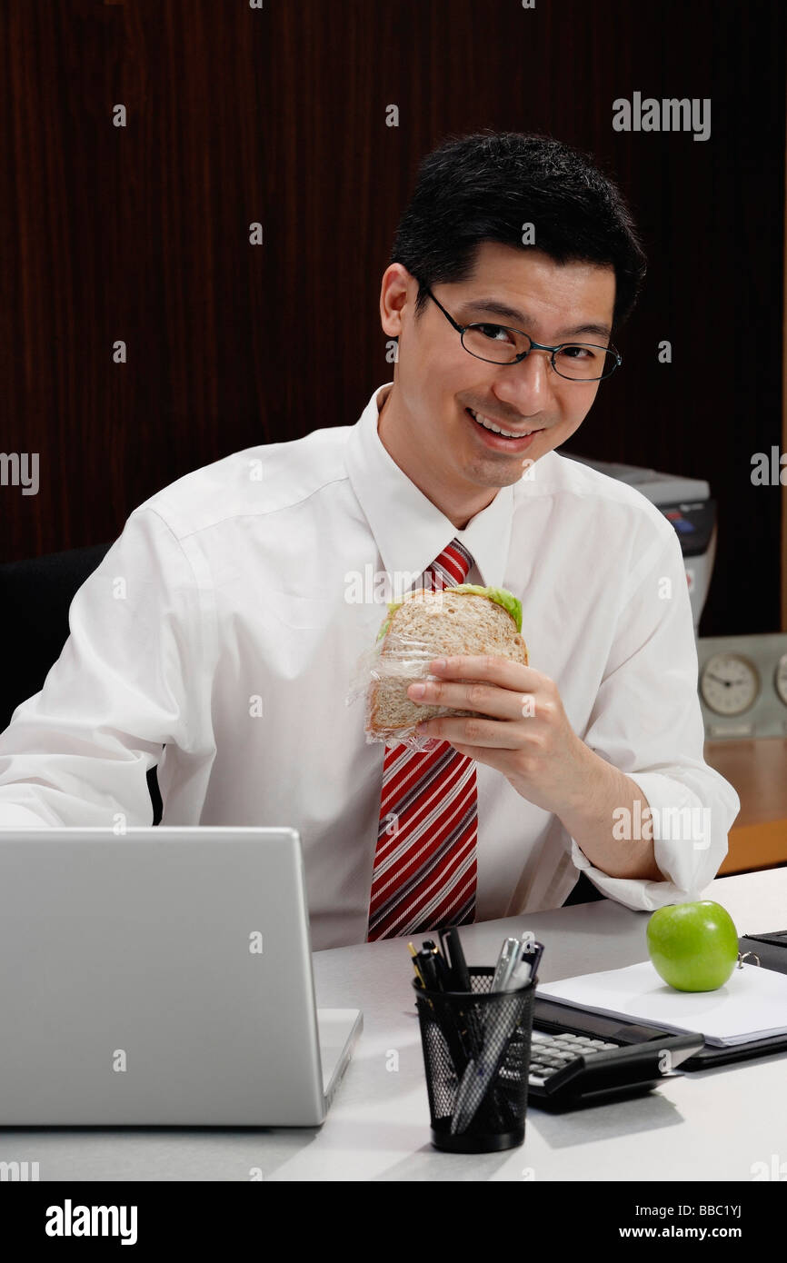 A man eats lunch at his desk Stock Photo - Alamy