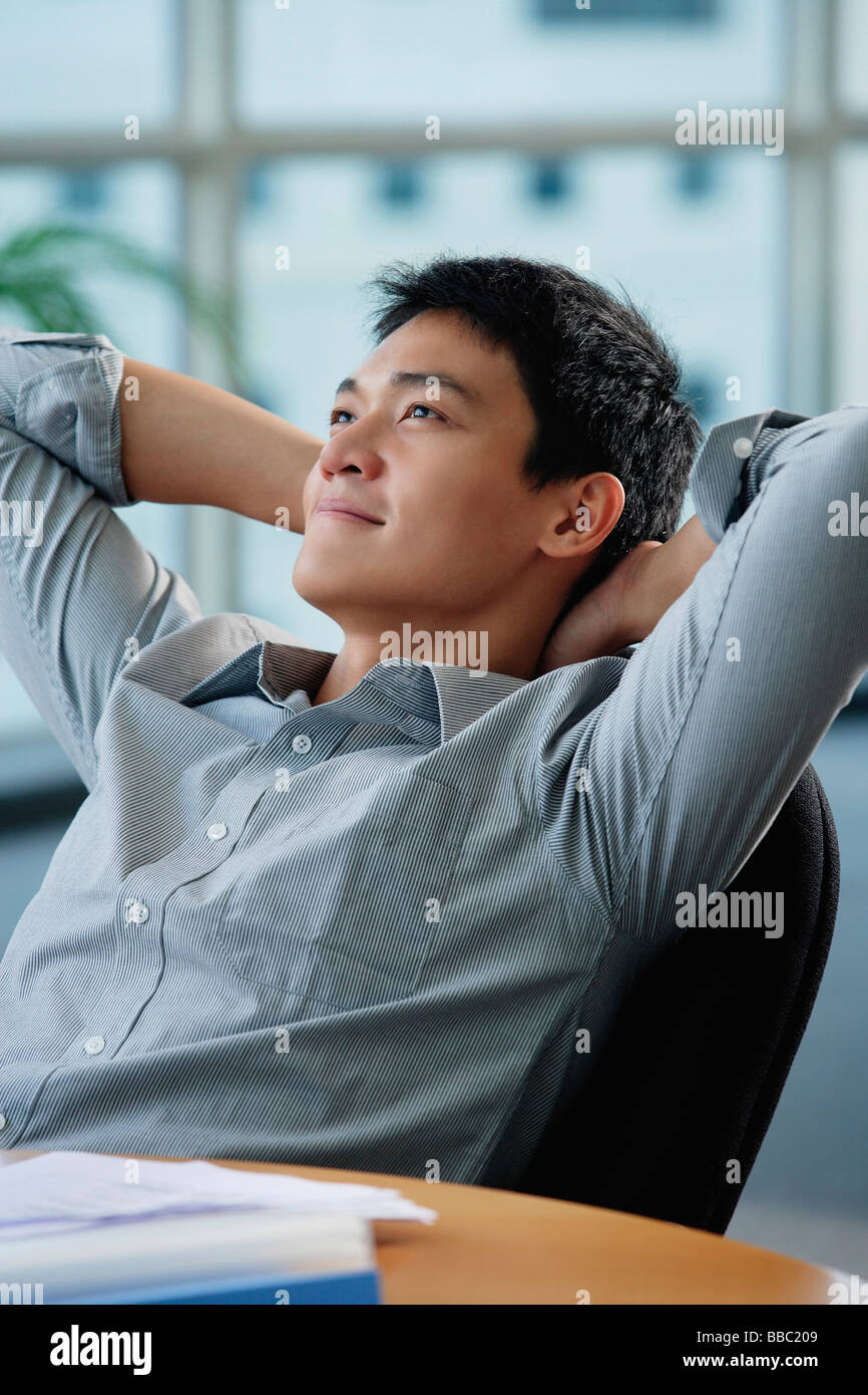 A man relaxes at his desk Stock Photo - Alamy