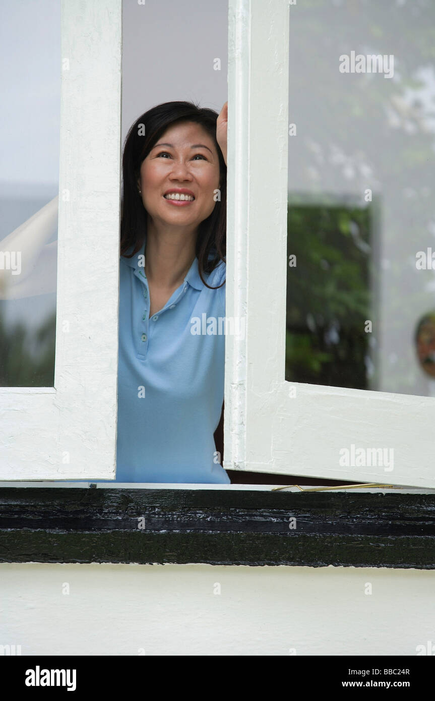 Woman opening windows, smiling Stock Photo - Alamy
