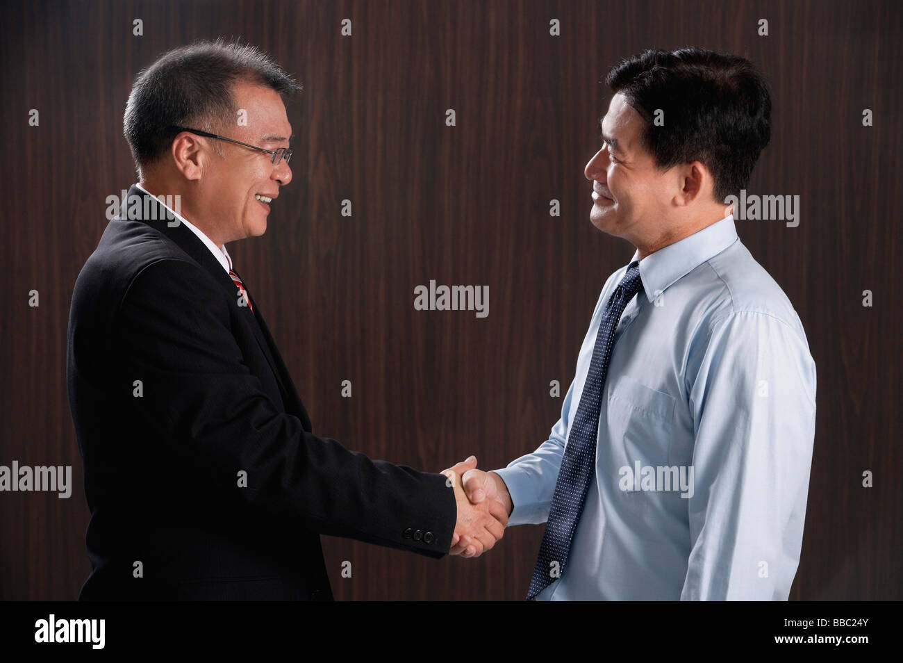 Two men smile and shake hands Stock Photo - Alamy