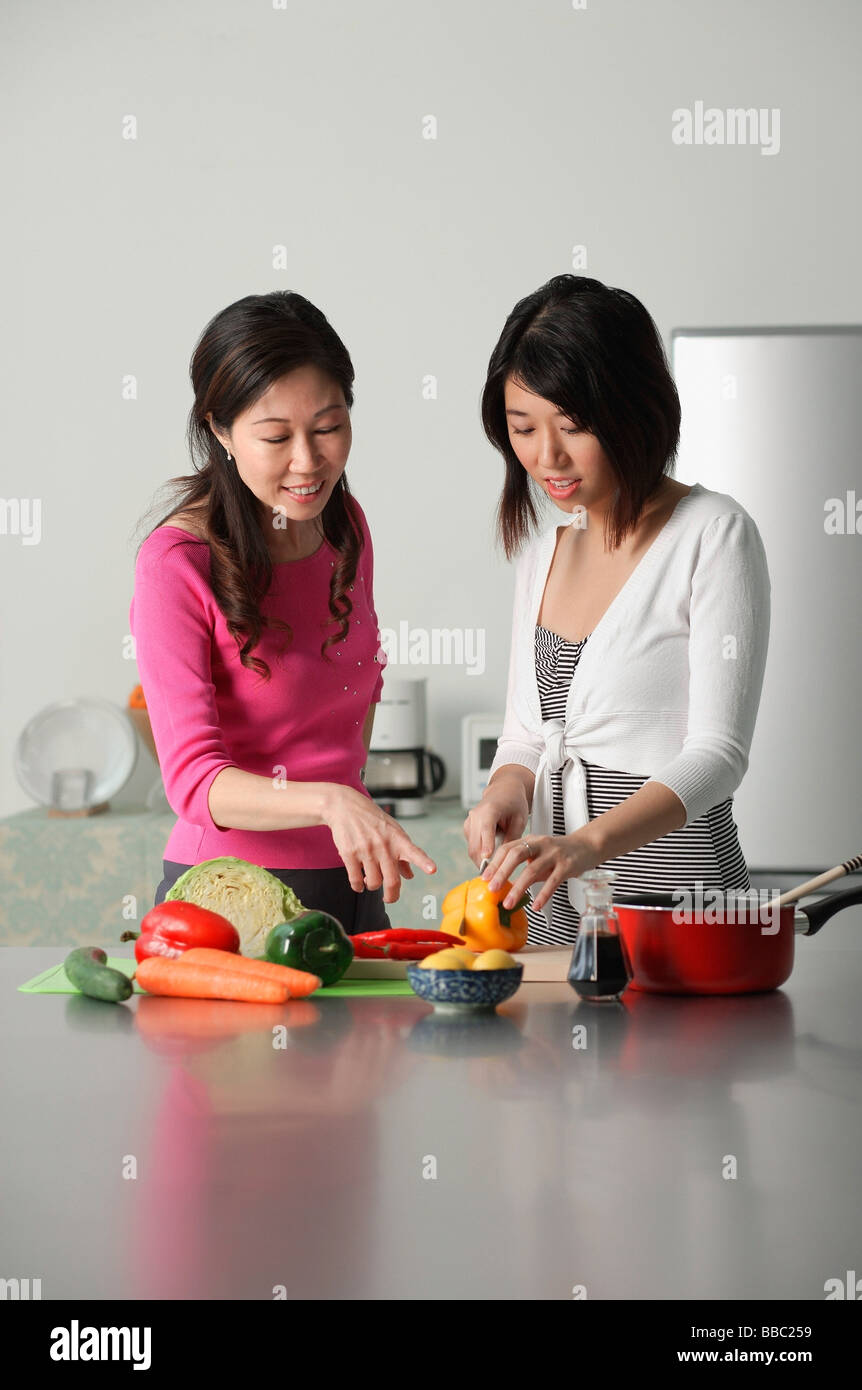 Mother guiding daughter in preparing a meal Stock Photo - Alamy