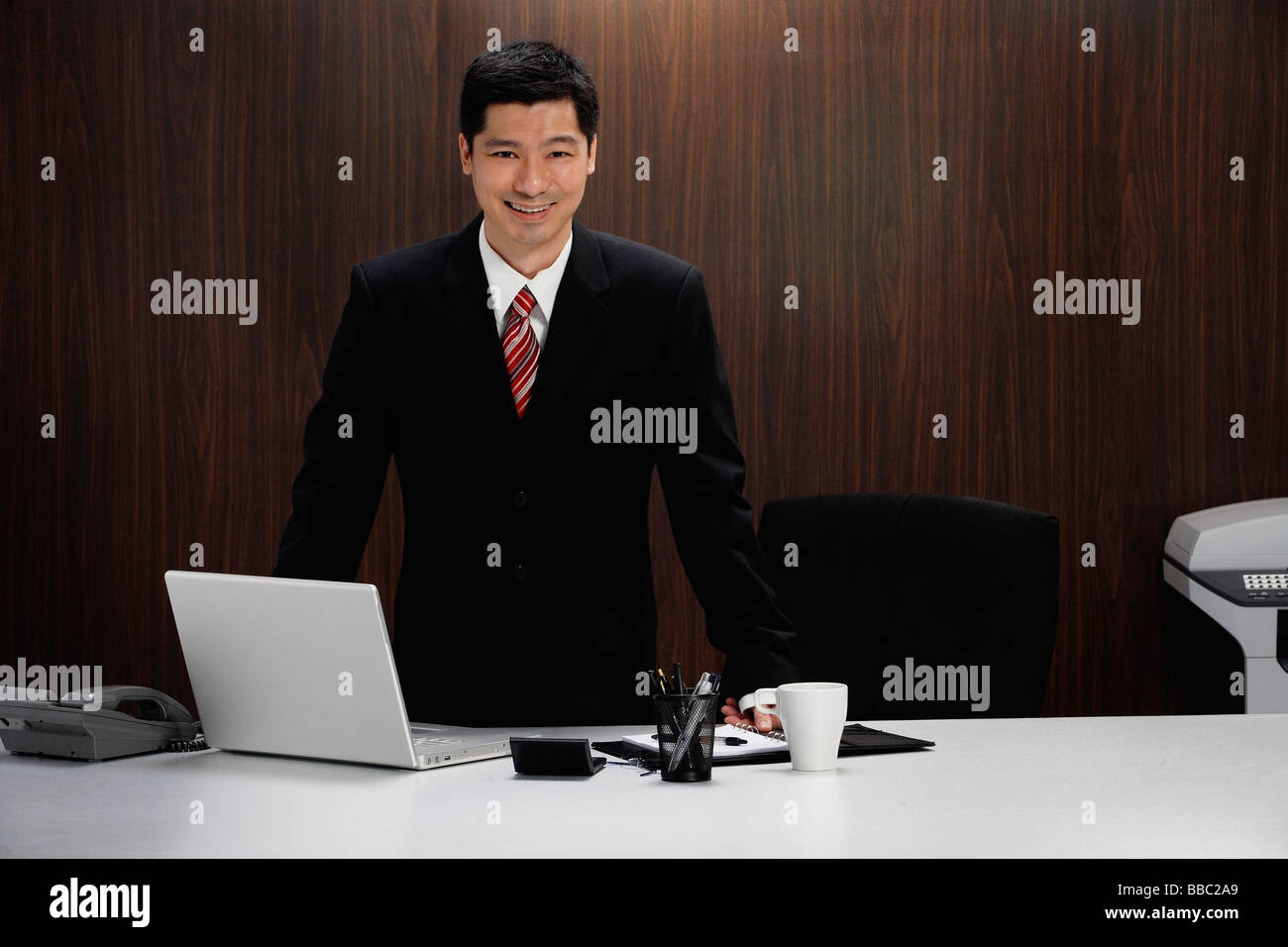 A businessman stands behind his desk Stock Photo - Alamy