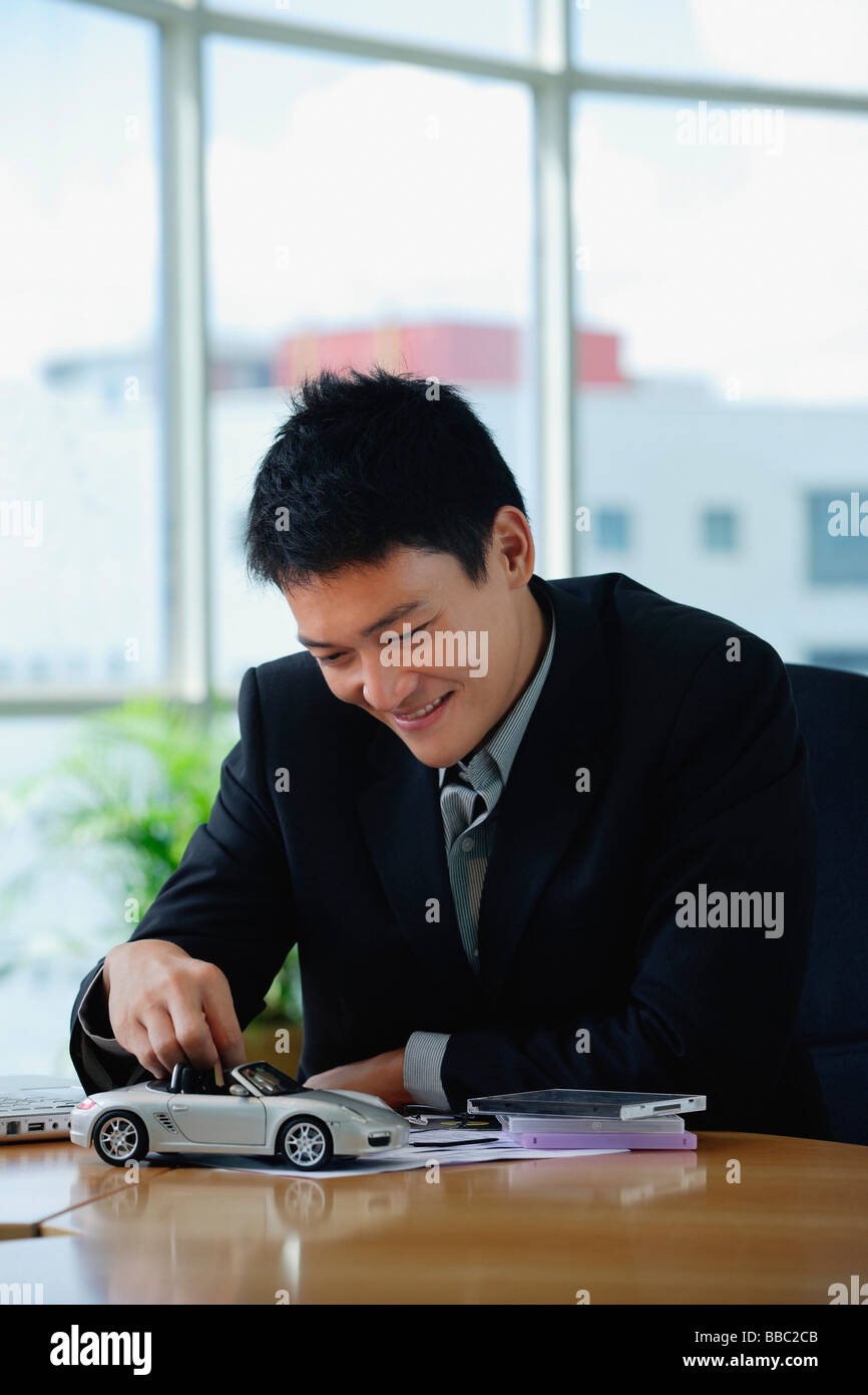 A man plays with a toy car on his desk Stock Photo - Alamy