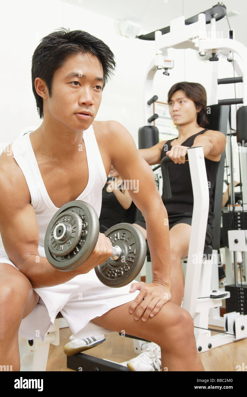 Young men working out in gym, looking away Stock Photo - Alamy
