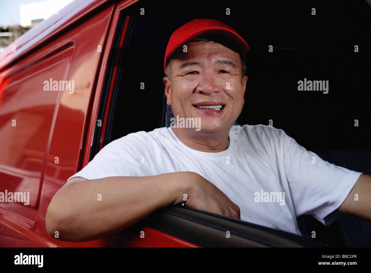 A man in a red van smiles at the camera Stock Photo - Alamy