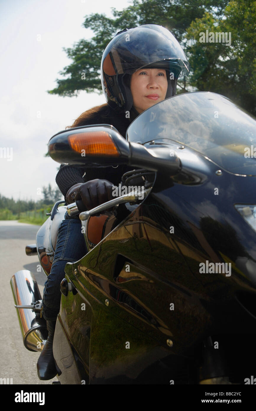 Mature woman riding motorcycle, wearing helmet Stock Photo - Alamy