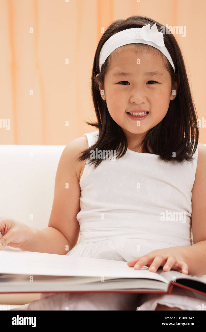 young girl, child, reading book, looking at camera, smiling Stock Photo ...