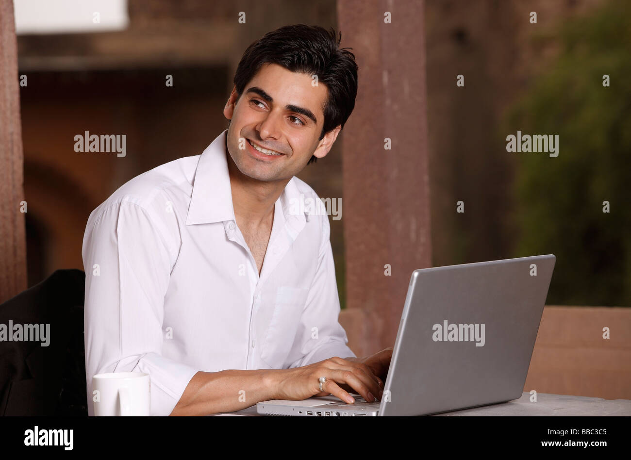 Young businessman with laptop looking sideways hi-res stock photography ...