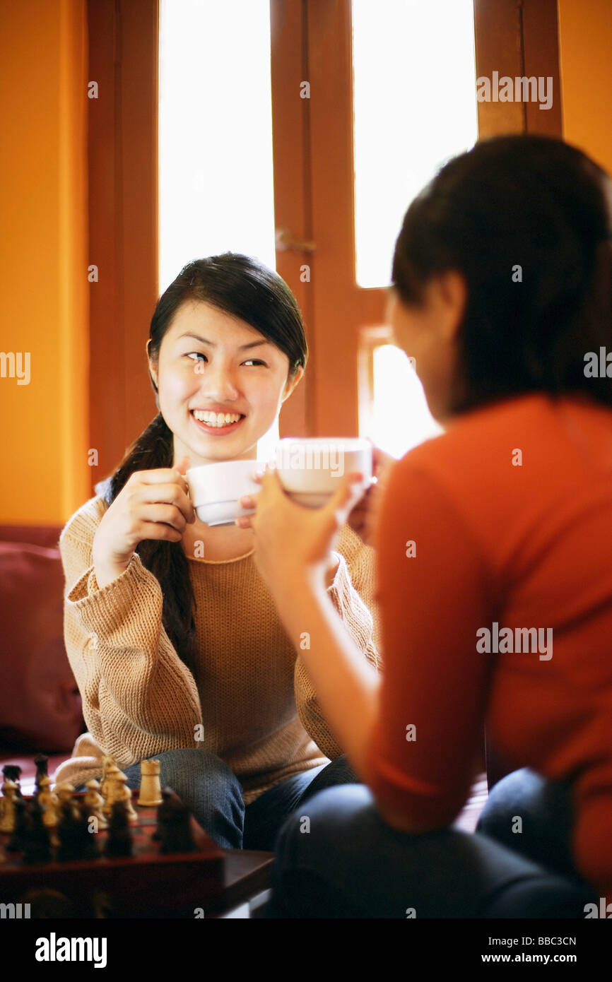 Two young women having tea Stock Photo - Alamy