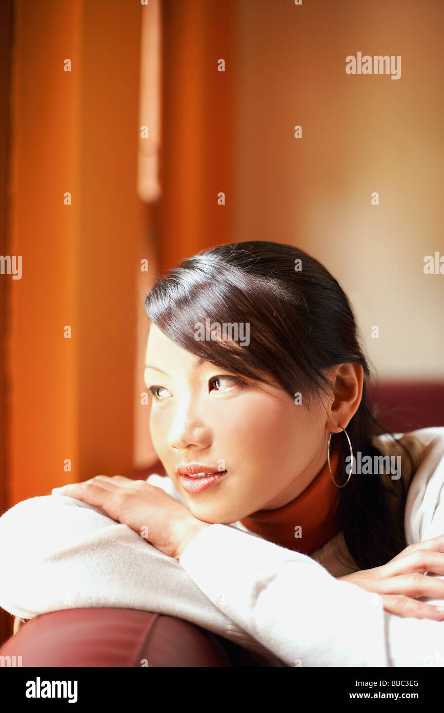 Young woman with arms crossed, head on arms, looking away Stock Photo ...