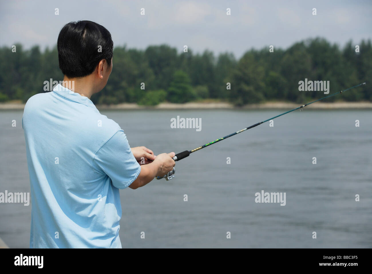 Man fishing with fishing pole, rear view Stock Photo - Alamy