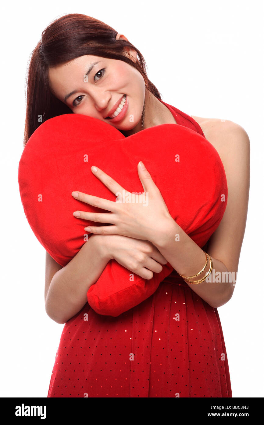 Happy woman hugging heart pillow hi-res stock photography and images ...