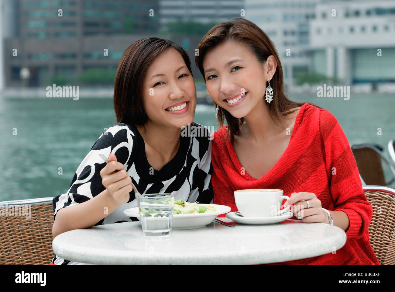 Two women at sidewalk cafe having lunch, smiling at camera Stock Photo ...