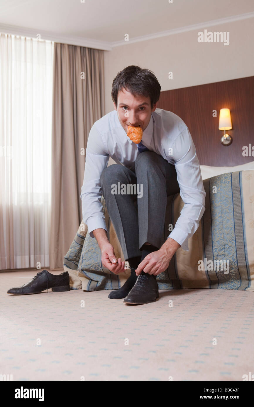 man eating while fastening his shoes Stock Photo - Alamy