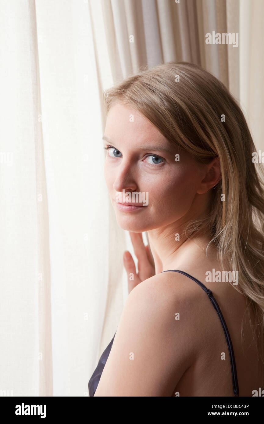 portrait of woman looking out of window Stock Photo - Alamy