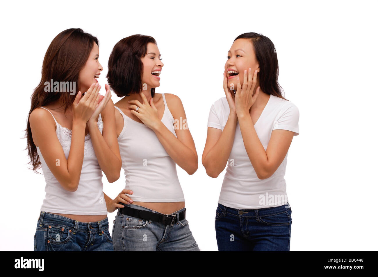 Three young women standing together and laughing Stock Photo - Alamy
