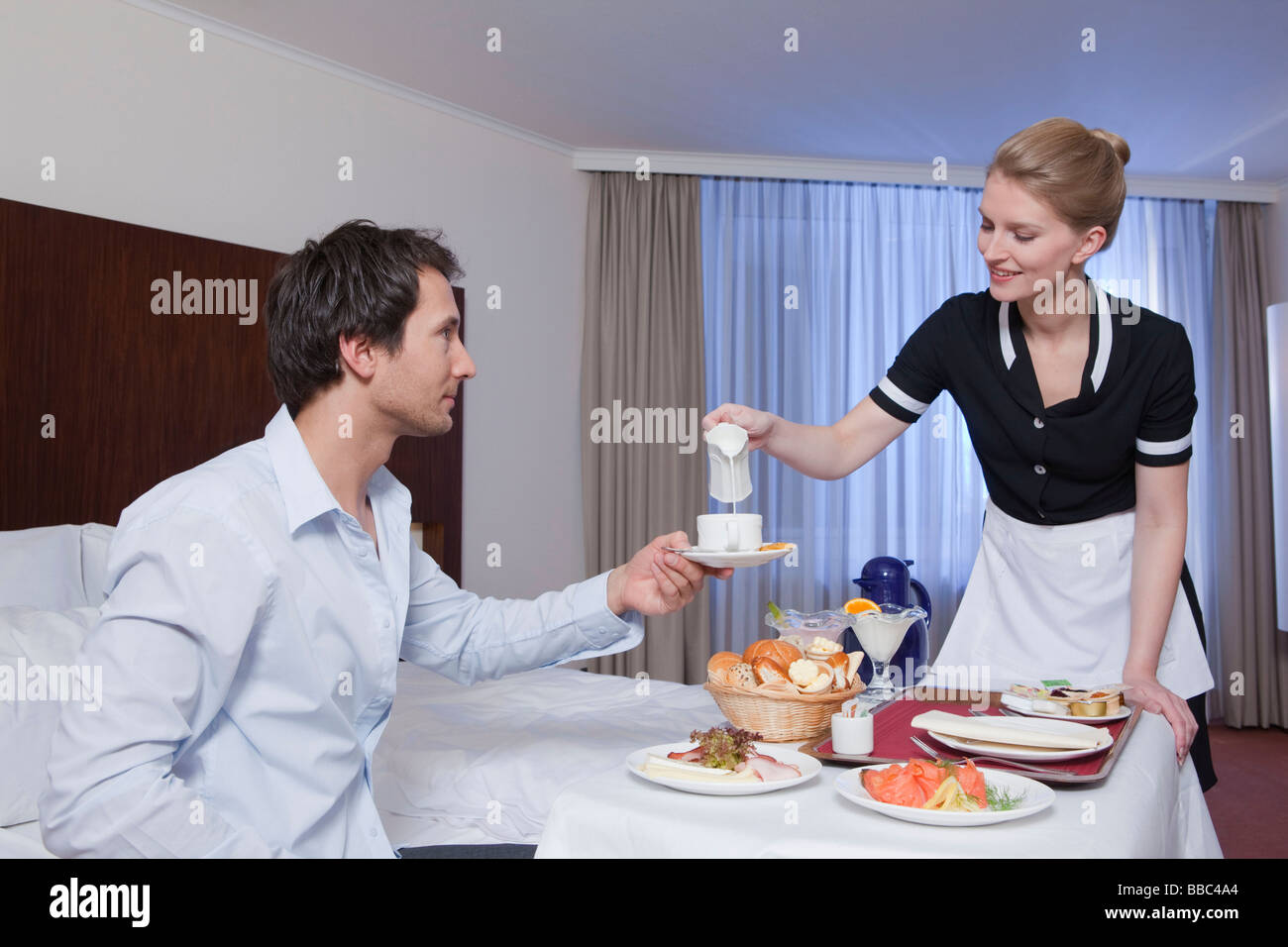 room maid serving businessman in his room Stock Photo - Alamy
