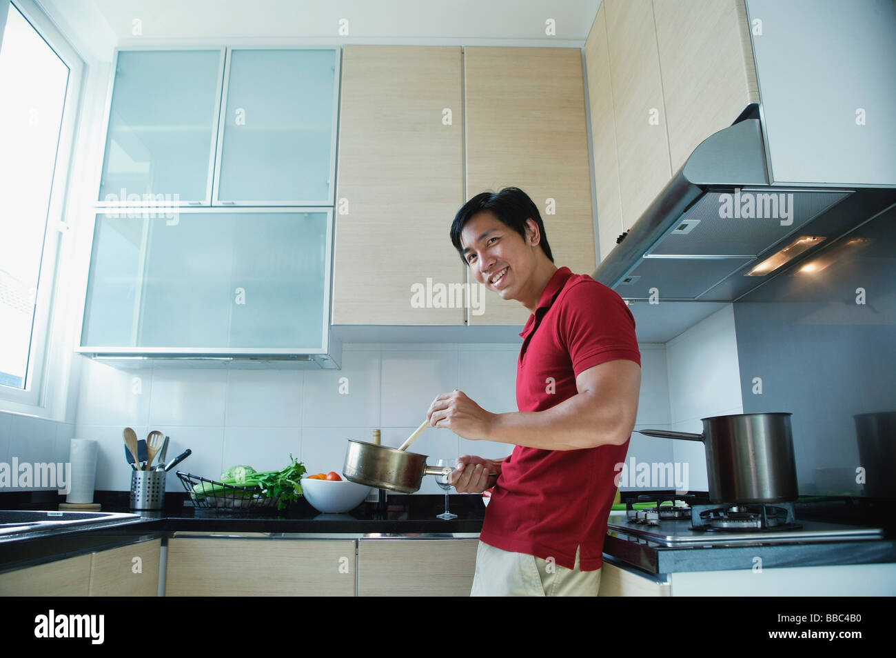 Man cooking in kitchen, smiling at camera Stock Photo - Alamy