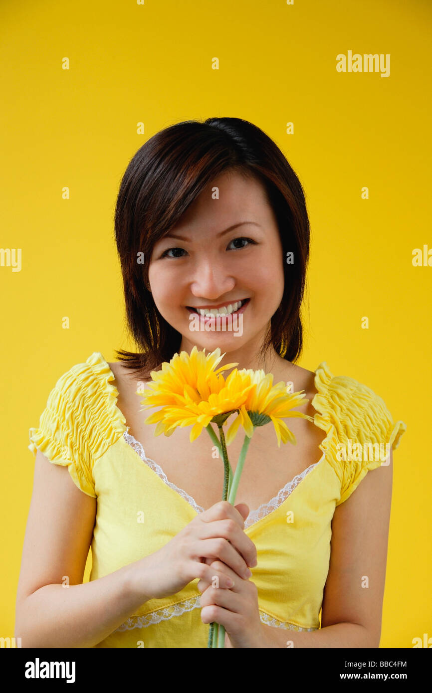 Young woman with stalks of yellow flowers Stock Photo - Alamy
