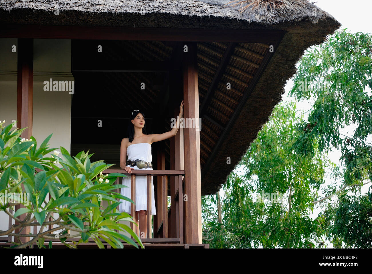 Young woman standing in balcony, looking out Stock Photo - Alamy
