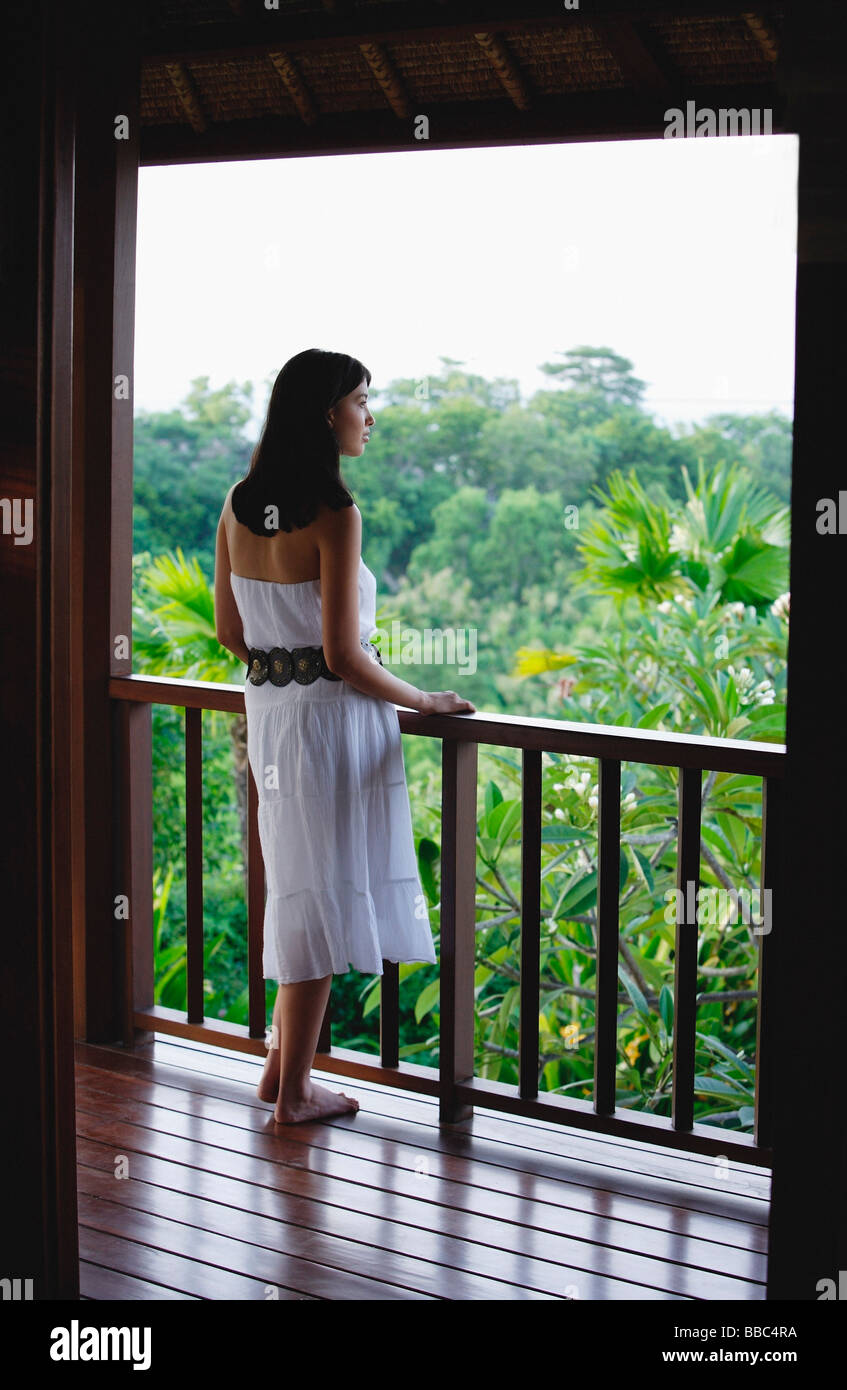 Young woman standing on balcony Stock Photo - Alamy