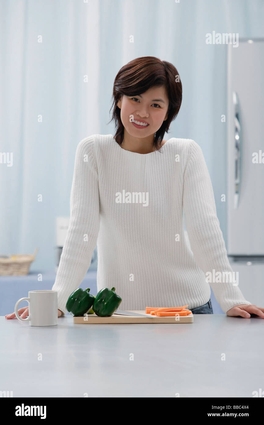 Woman in kitchen, smiling at camera Stock Photo - Alamy