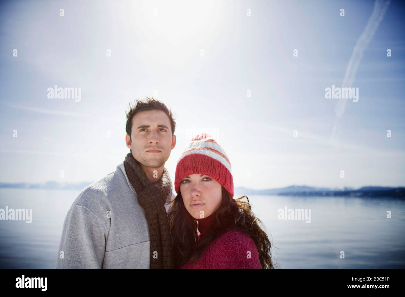Couple looking into distance by lake Stock Photo - Alamy